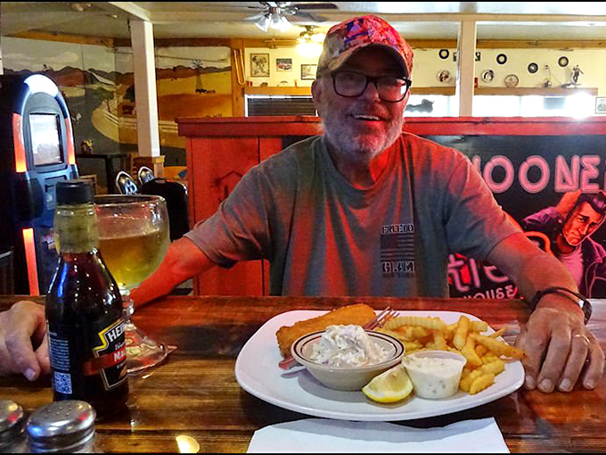 Happy diners and golden-fried goodness&mdash;the universal language of roadside satisfaction. That smile says everything about the 50's Road House experience.