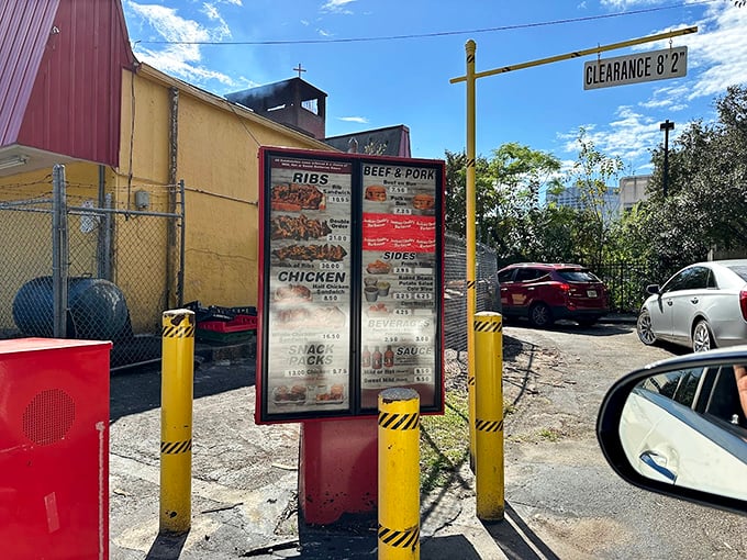 The drive-thru menu board stands like a roadside shrine, promising salvation for those too hungry to leave their vehicles.