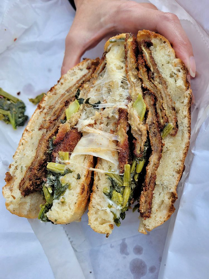 Broccoli rabe proudly taking center stage between sesame-seeded bread. Green vegetables never had a more glorious moment in the spotlight.