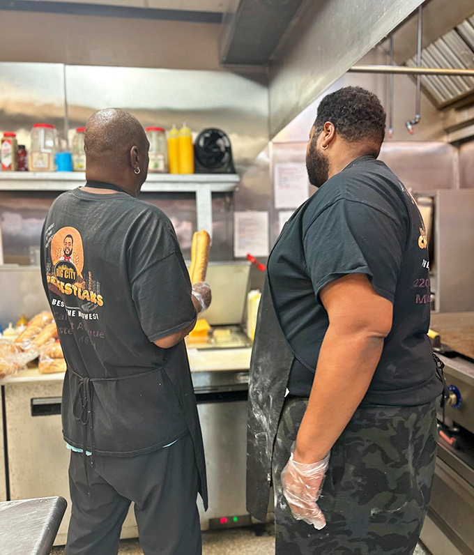 The magic happens here—skilled hands preparing the next round of cheesesteak perfection. This is where dreams are made, one sandwich at a time.
