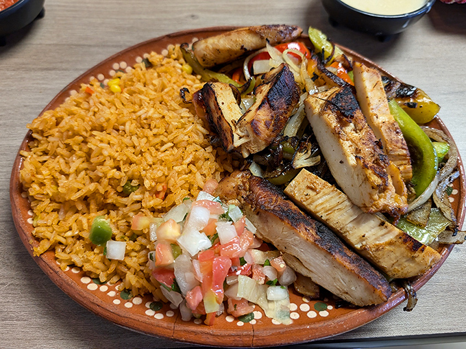 Perfectly charred chicken fajitas share real estate with fluffy Spanish rice and freshly chopped pico de gallo—the holy trinity of Mexican cuisine.