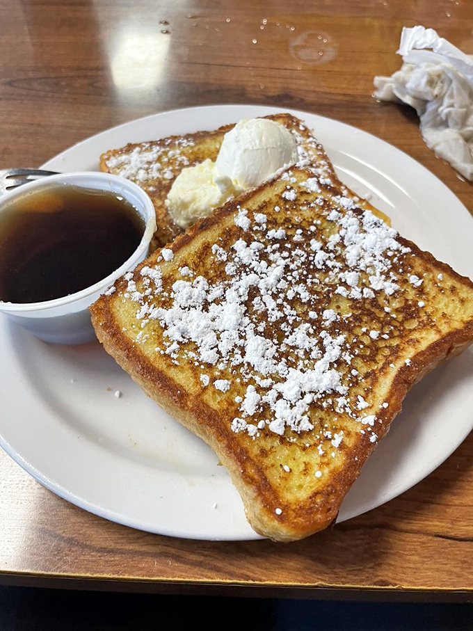 French toast that makes pancakes jealous. That powdered sugar snowfall and melting butter pat are performing a breakfast ballet on your plate.