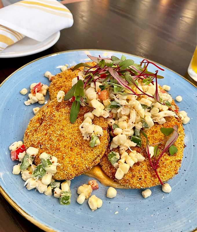 Fried green tomatoes get the coastal treatment with a golden cornmeal crust and fresh corn salad topping&mdash;Southern tradition meets Delaware innovation.