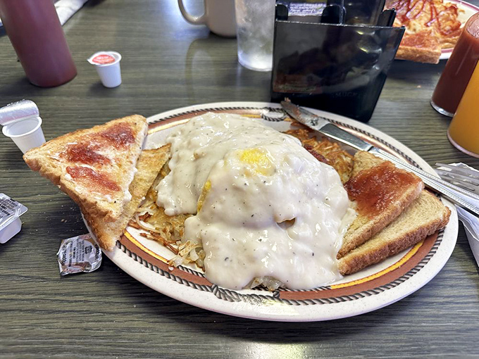 The "Gut Buster" lives up to its name—a gravity-defying monument to breakfast excess draped in creamy country gravy.