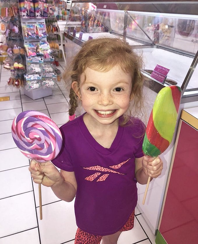 The look of pure joy that adults spend thousands on therapy trying to recapture. Two lollipops, one happy kid, zero nutritional value.