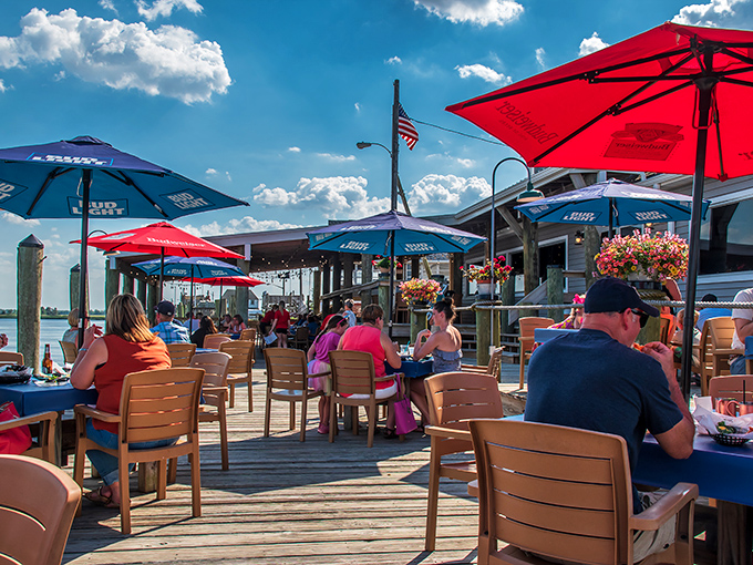 Red and blue umbrellas create a patriotic canopy over the deck, where diners soak up sunshine and sea breezes between bites.