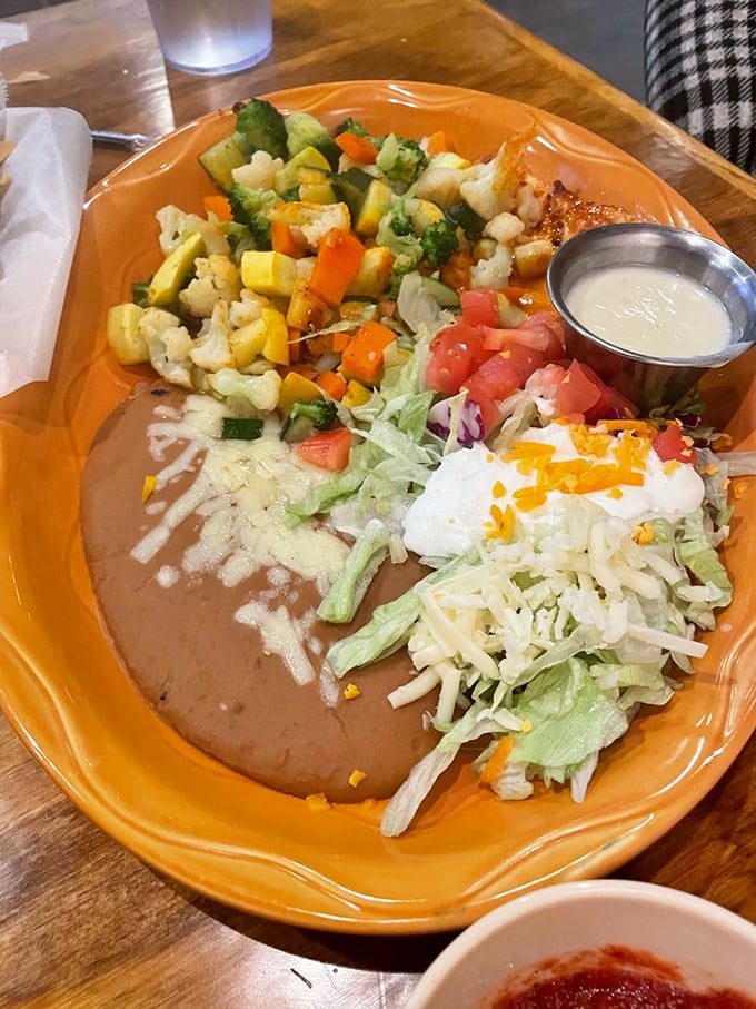 A plate so colorful it could double as modern art. Those veggies, beans, and cheese create the Mexican flag effect that promises authentic flavor.