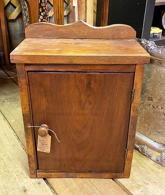 This humble wooden cabinet once organized someone's daily essentials. Its worn surface tells of countless openings and closings&mdash;a quiet witness to domestic routines.
