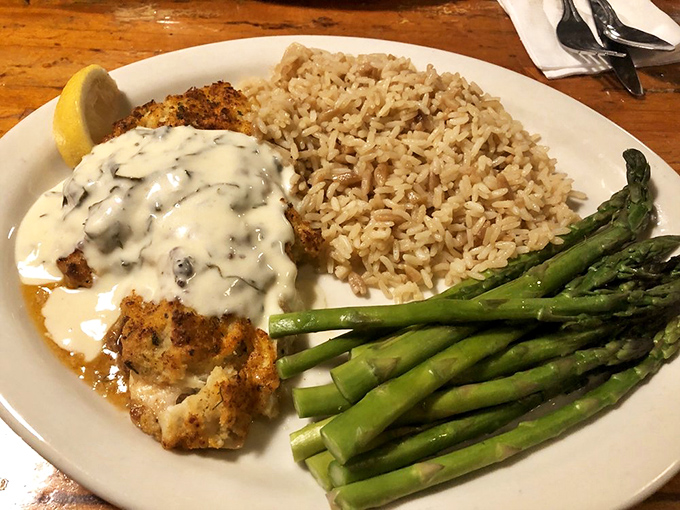 This isn't just fish&mdash;it's a seafood masterpiece where snapper meets crab under a blanket of creamy sauce, with asparagus standing by for a touch of green virtue.