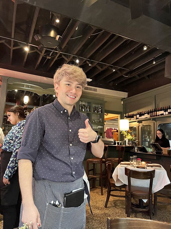Service with a genuine smile and a thumbs-up. When your server looks this happy, you know you've chosen the right restaurant.