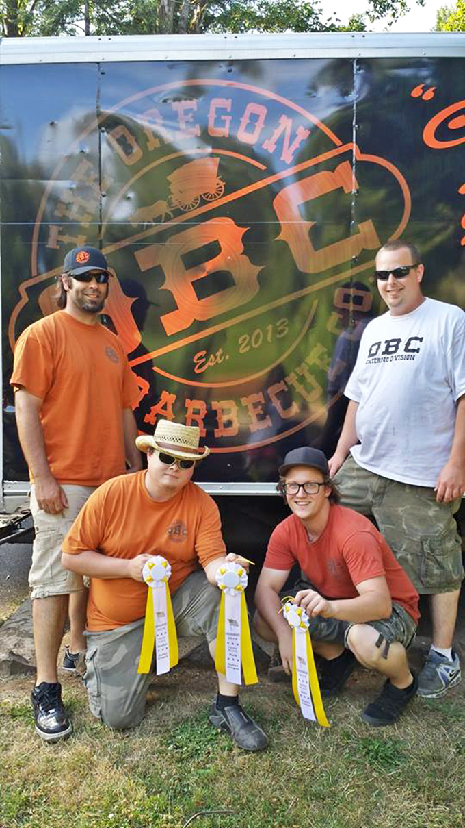 The image shows what appears to be team members with award ribbons, celebrating their barbecue achievements with well-deserved pride.