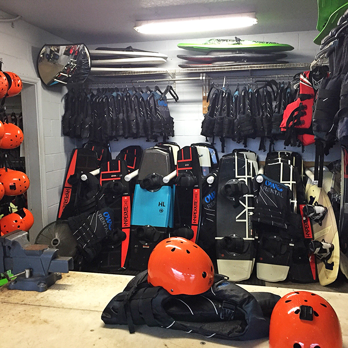 The equipment room looks like a superhero's closet—where ordinary humans transform into wakeboarding warriors with the right gear.