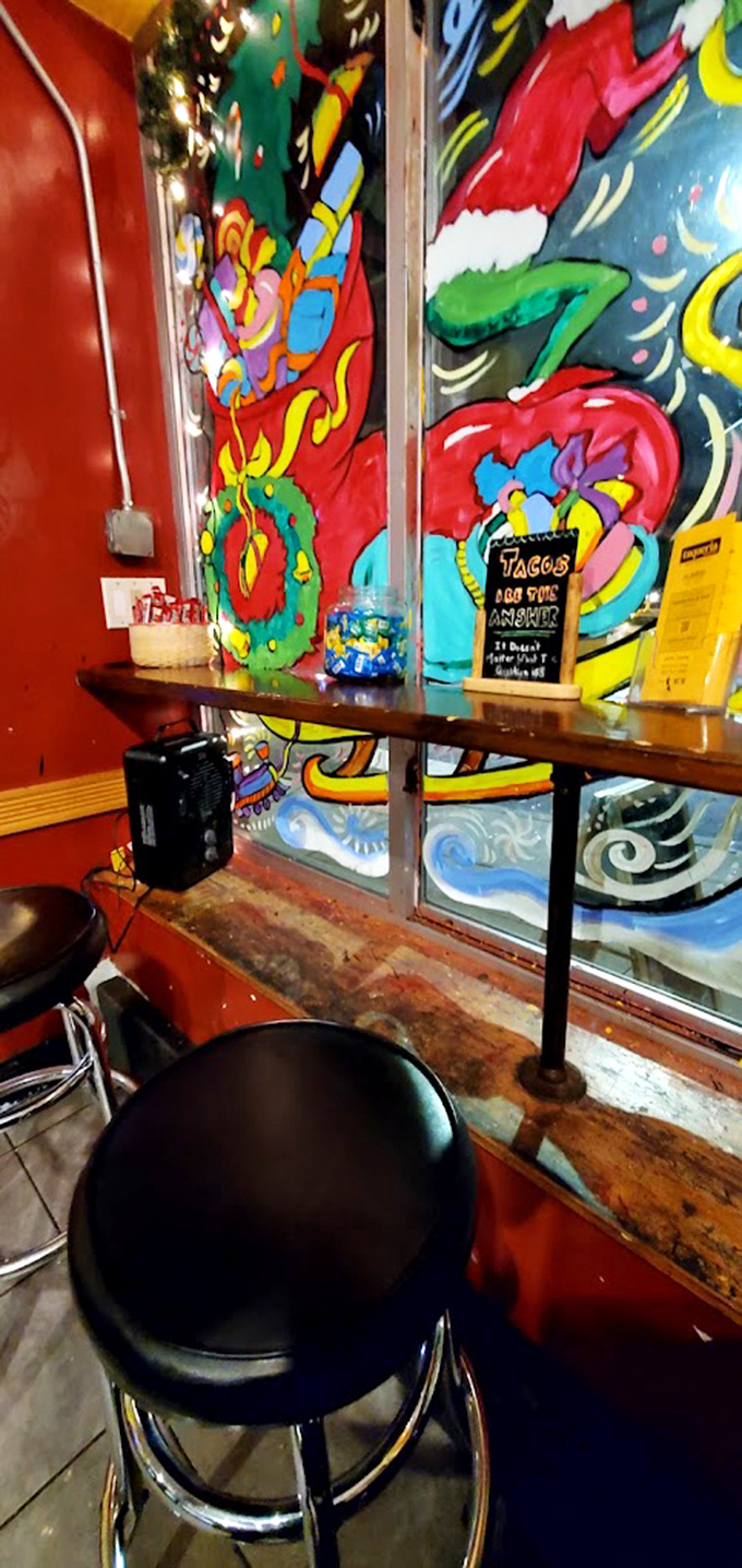 Vibrant murals and simple seating create the perfect backdrop for serious taco contemplation. That sign might as well say "Flavor happens here."