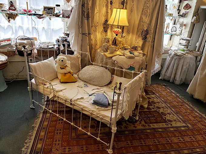 This antique baby bed staged with vintage linens and a teddy bear creates an irresistible tableau of childhood nostalgia.