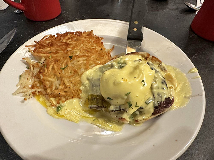 Benedict elevated to art form: Hollandaise cascades over perfectly poached eggs and savory meat, with crispy hash browns standing guard &ndash; breakfast nirvana achieved.