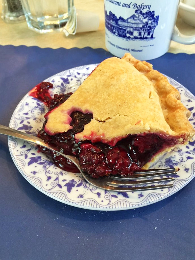 That blackberry filling, dark as midnight and twice as mysterious. The perfect fork-full reveals berries that burst with sunshine-soaked flavor.