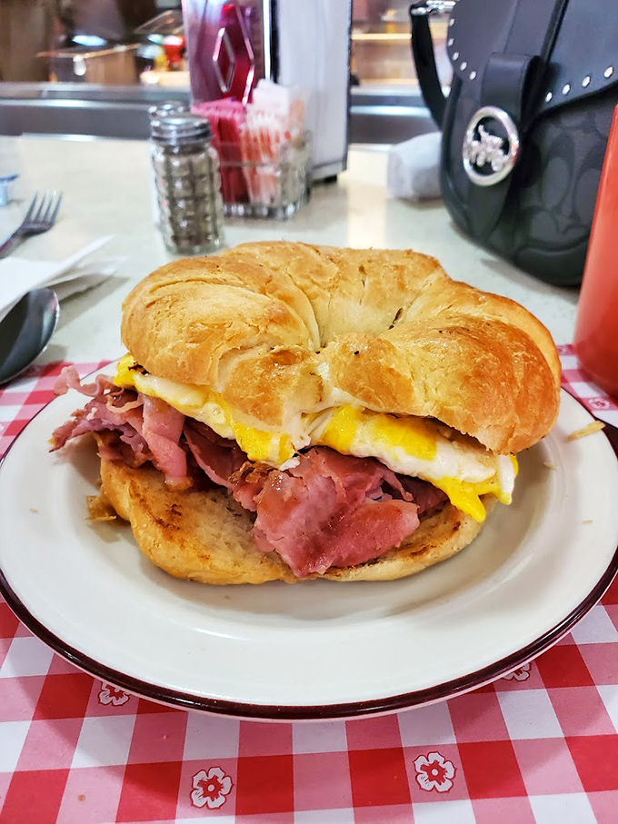 Breakfast sandwich architecture at its finest. The structural integrity of that croissant supporting eggs and ham deserves an engineering award.