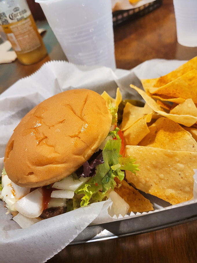 A burger that doesn't need seafood's spotlight to shine, flanked by tortilla chips standing guard like crispy sentinels.