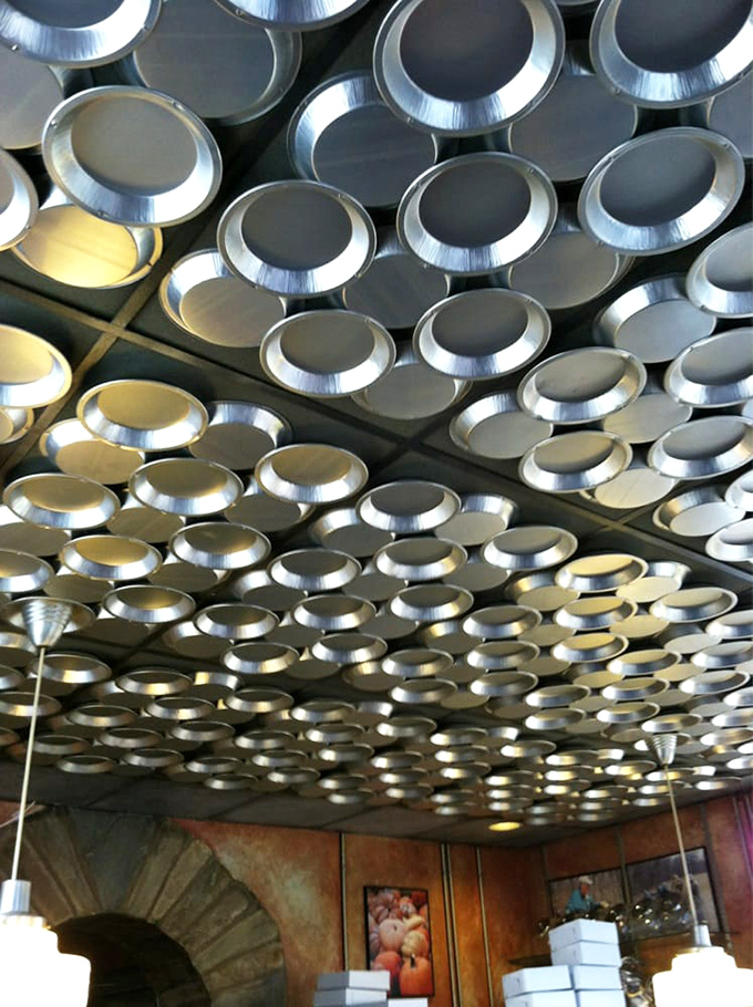 The ceiling that launched a thousand Instagram posts. These pie tins create a silver galaxy overhead&mdash;baking tools transformed into industrial chic.
