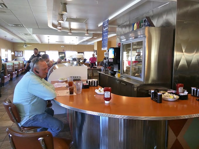 The curved counter isn't just functional&mdash;it's social architecture, designed to make strangers into neighbors over cups of bottomless coffee.