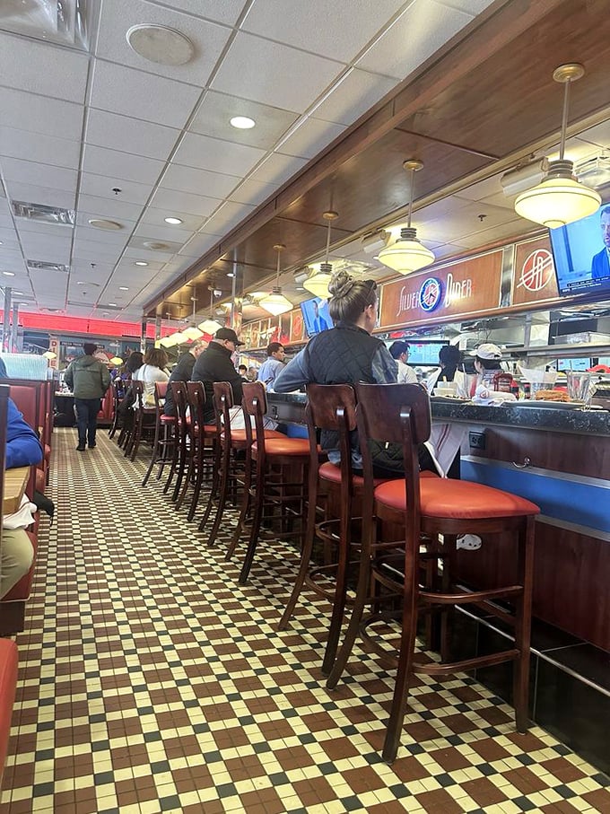The diner's counter culture in full swing—where strangers become temporary neighbors united by coffee refills and the universal language of comfort food.