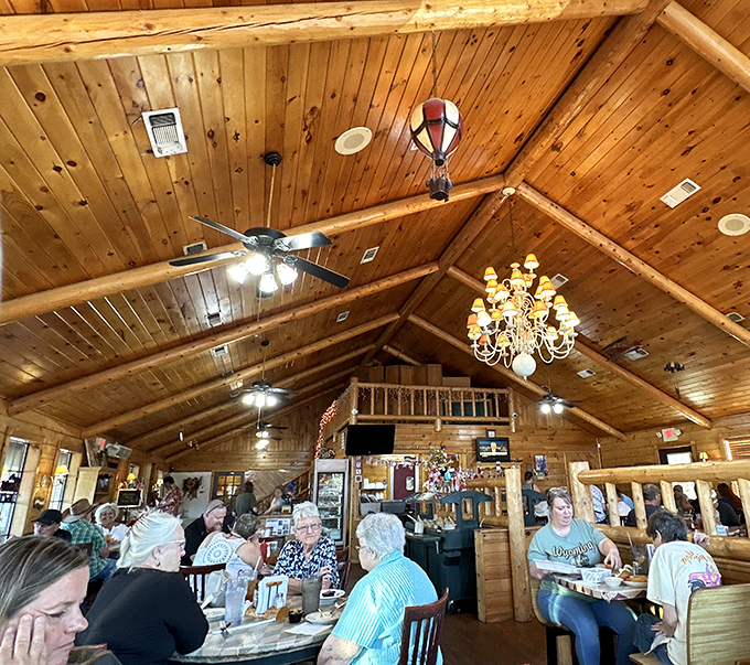 The dining room buzzes with conversation and laughter under rustic wooden beams. Good food brings people together in this cabin-like setting.