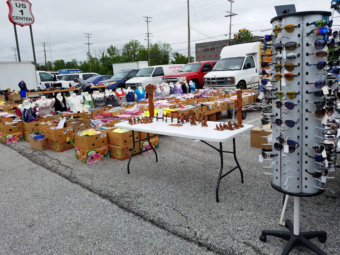 Outdoor vendor row&mdash;where sunglasses and sunscreen become essential shopping tools and treasures spill from tables onto asphalt.