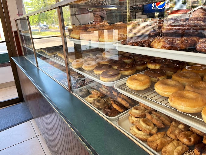 The display case offers a geography lesson in deliciousness—each shelf an island of possibility in a sea of hunger.