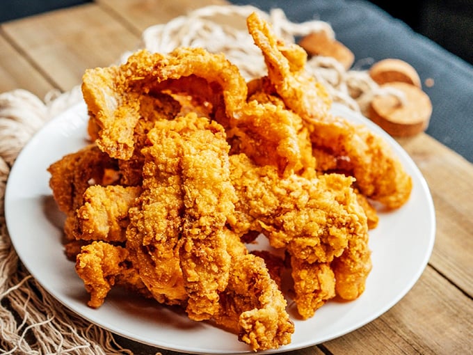 A mountain of golden-fried treasures from the deep, arranged like a crown jewel on a simple white plate&mdash;no fancy garnish needed.