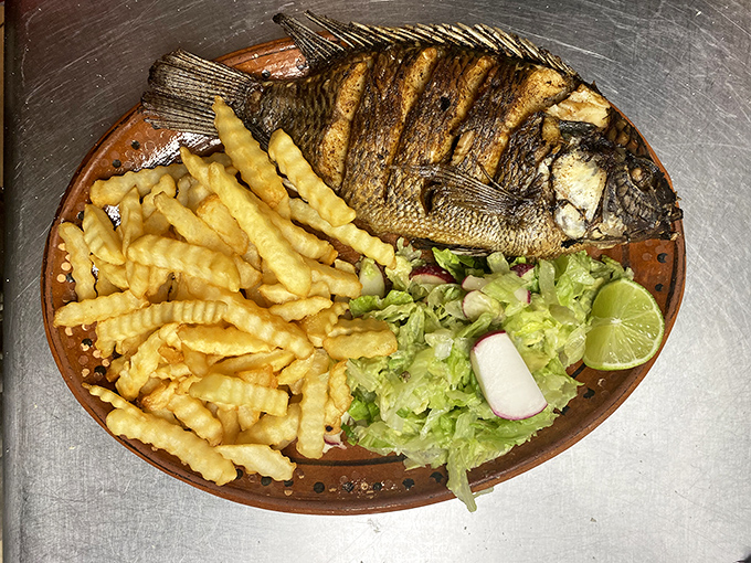 This fried fish platter proves El Cantarito isn't just about meat&mdash;crispy perfection with fries and fresh garnishes for a coastal detour.