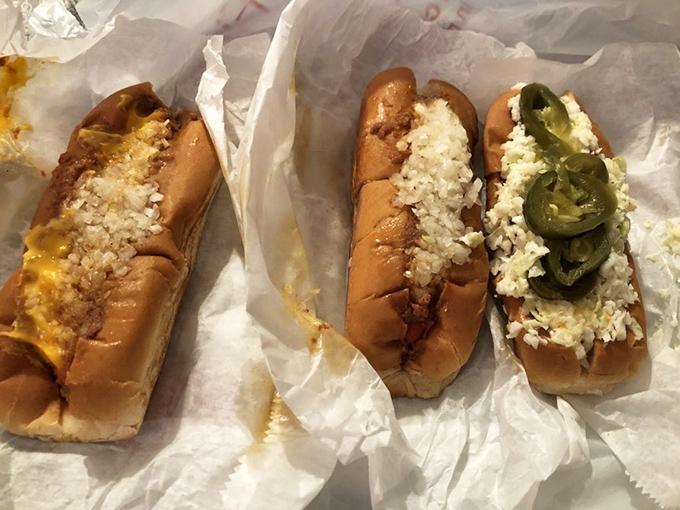 Three distinct personalities on display: the cheese devotee, the slaw enthusiast, and the jalapeño adventurer. Choose your fighter.