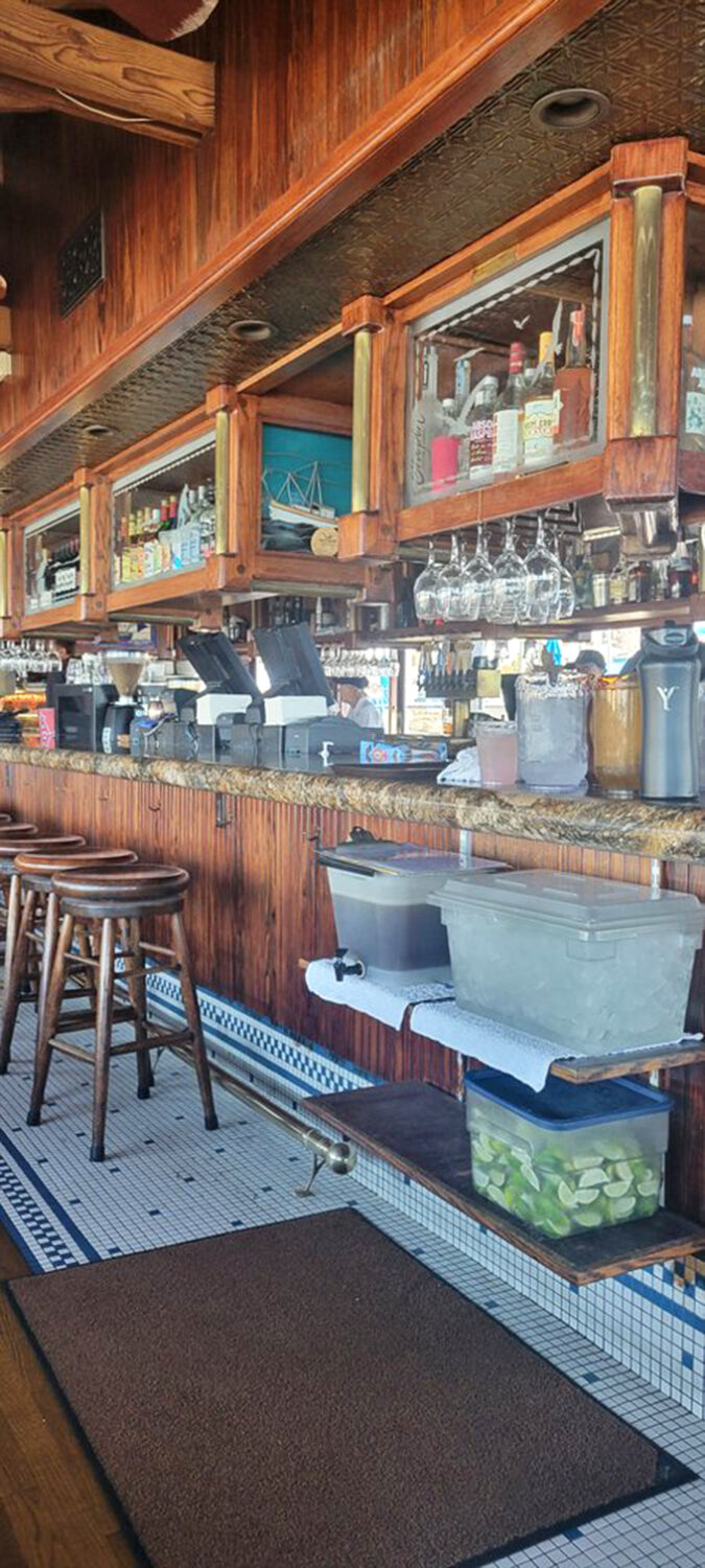 The bar area's warm wood tones and nautical touches create the perfect backdrop for sea stories and sunset cocktails.