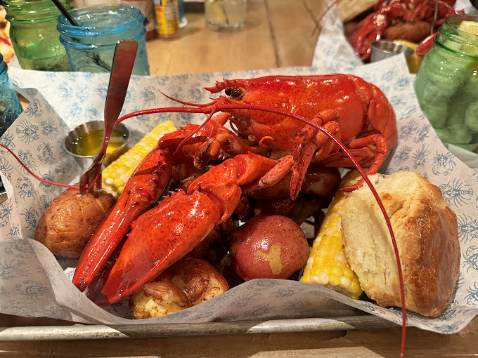 The classic seafood boil arrives like edible art &ndash; a crimson crustacean presiding over potatoes and corn, demanding both respect and drawn butter.
