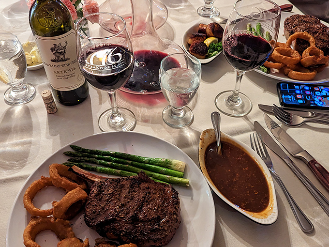 A premium cut shares the spotlight with perfectly charred asparagus and golden onion rings &ndash; a trifecta of comfort that defines steakhouse excellence.