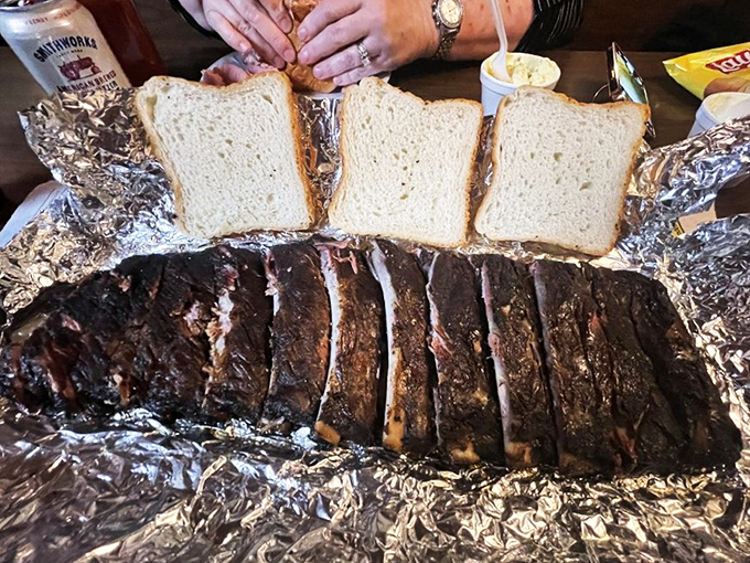 Ribs sliced and ready for their close-up, with white bread standing by for sauce-sopping duty. This is Kansas poetry written in smoke, meat, and time.