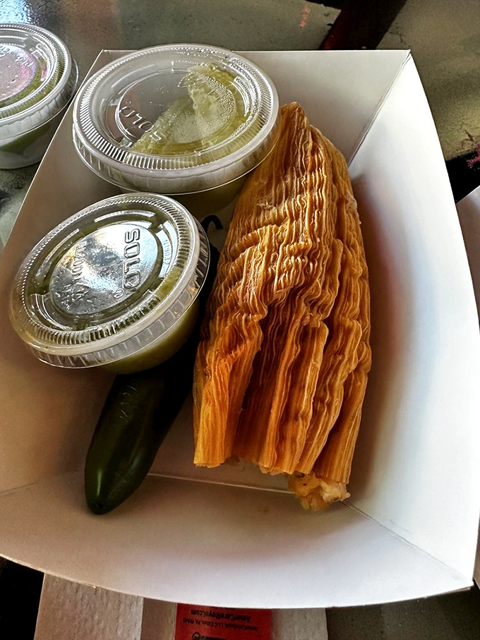 The to-go experience: one perfect tamale, a roasted jalape&ntilde;o, and dipping sauces. This humble box contains more joy than packages ten times its size.