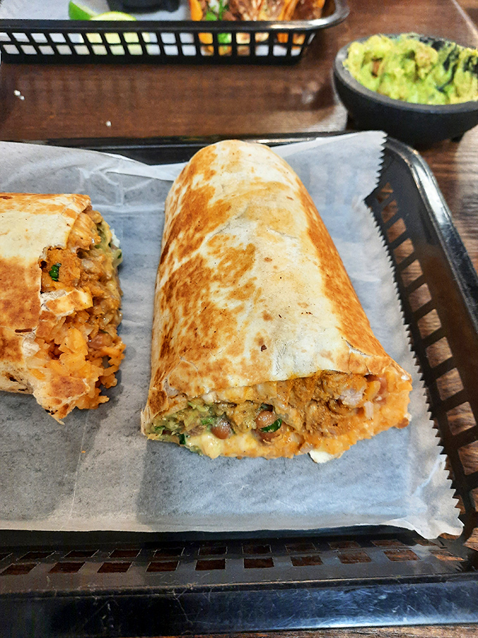 Behold: the burrito in its natural habitat, accompanied by its faithful sidekick, guacamole. A partnership that rivals Batman and Robin.