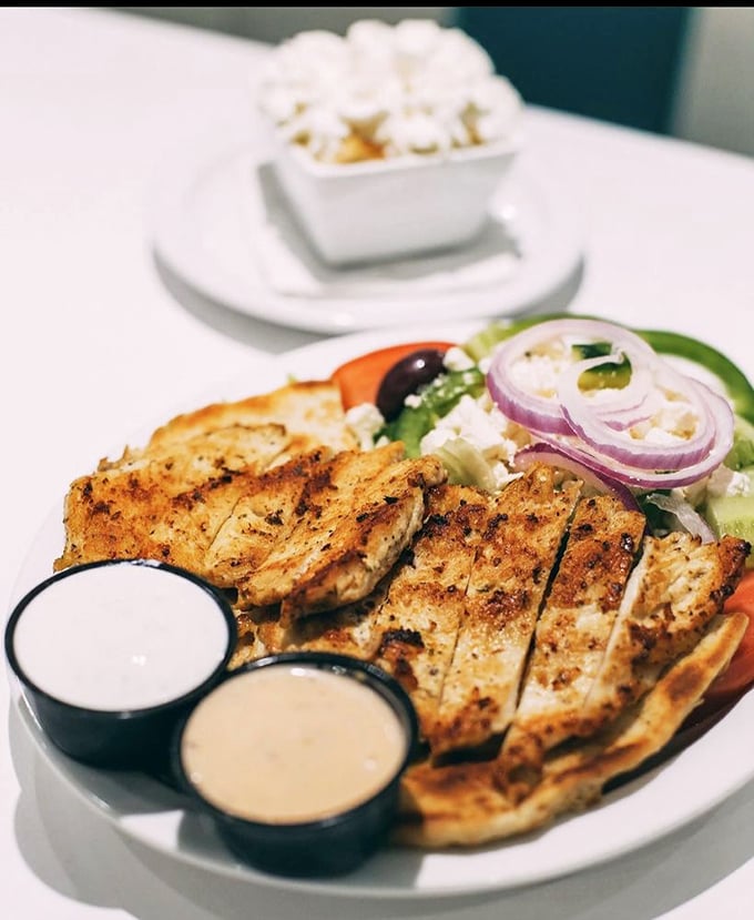 Protein meets freshness in this grilled chicken salad masterpiece. Two dipping sauces because life's too short for condiment monogamy.