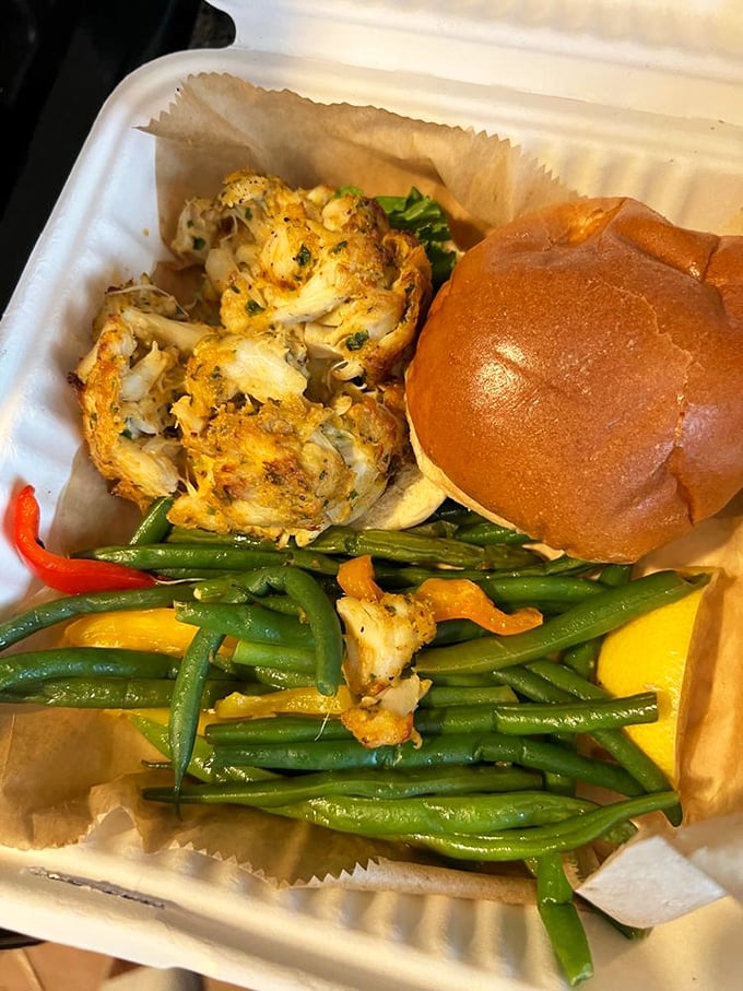 Even in takeout form, the crab cake maintains its dignity&mdash;golden brown, accompanied by vibrant green beans that dare you to call them a mere side dish.