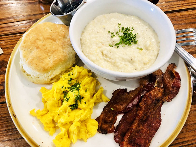 The holy trinity of Southern breakfast: fluffy biscuit, creamy grits, and eggs that practically glow. Add bacon and you've got breakfast nirvana.