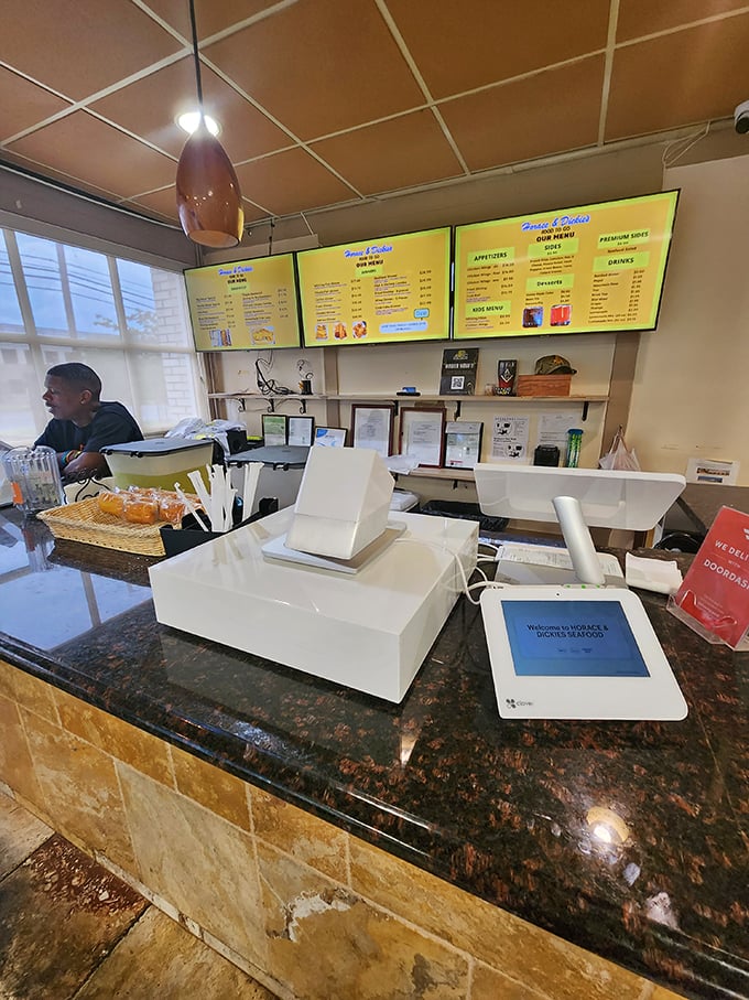 The command center &ndash; where digital meets delicious. Behind that counter, seafood magic happens with methodical precision.