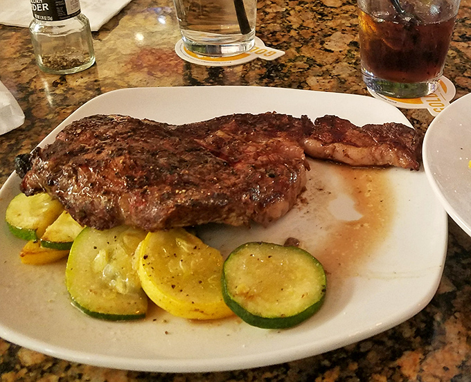 A steak that's been introduced to heat with respect and reverence. Those zucchini slices aren't garnish—they're vegetables that finally found their purpose in life.