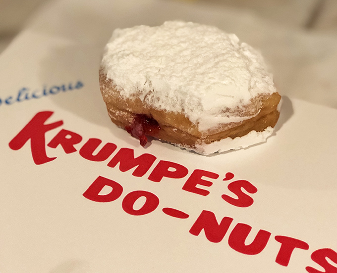 The jelly-filled powdered donut, resting on its branded napkin, offers a sweet reminder that some traditions need no improvement. Simple, timeless perfection.