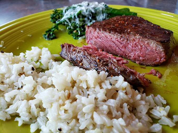 That perfect medium-rare steak nestled beside fluffy rice and creamy greens &ndash; proof that seafood isn't the only star at this coastal gem.