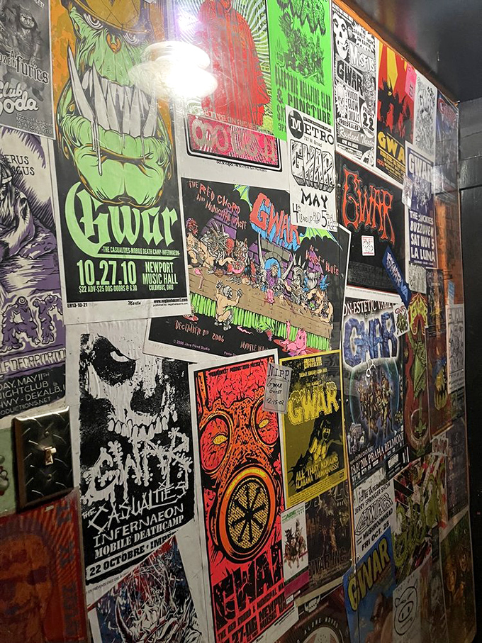 A wall of concert posters that serves as both decoration and a timeline of questionable graphic design choices.