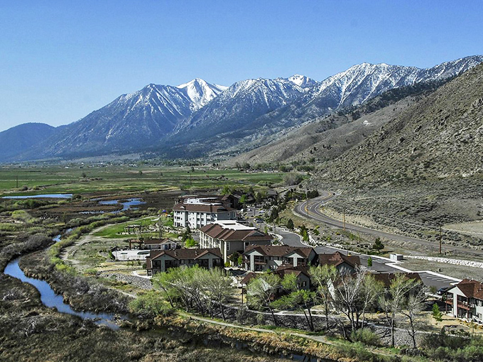 The serene reflecting pond creates a perfect mirror image of the mountains, doubling the majesty of Nevada's dramatic landscape.