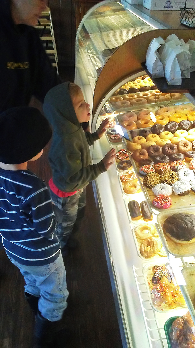 The wide-eyed wonder of children selecting donuts is the purest form of joy—a reminder that some pleasures never lose their magic.