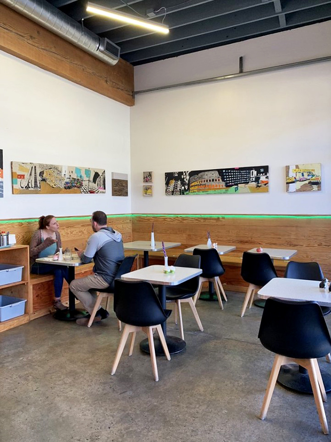 Modern minimalism meets comfort in this dining area where art adorns the walls and conversations flow as smoothly as cream filling.