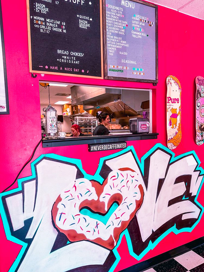 Where donut dreams come true: The order counter showcases both savory and sweet options beneath vibrant pink walls and street-art style declarations of love.