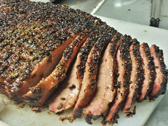 Brisket sliced like butter. Each piece showing that perfect pink smoke ring that barbecue aficionados chase like treasure hunters.